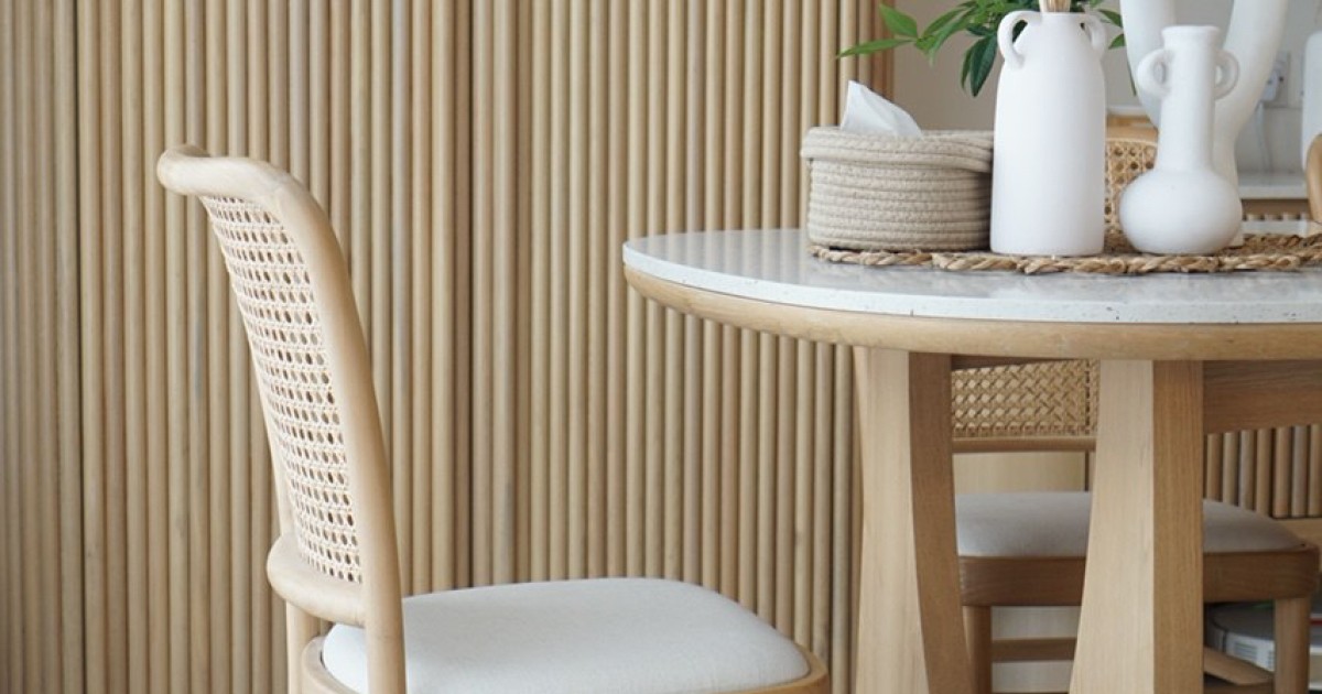 A modern quartz or marble dining table with a sleek, rounded ...